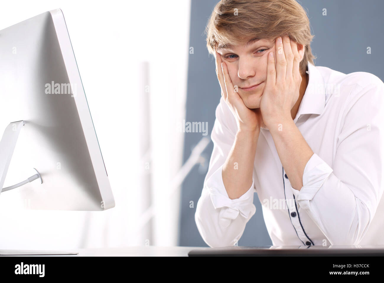 Working behind a desk, a handsome young employee Stock Photo - Alamy