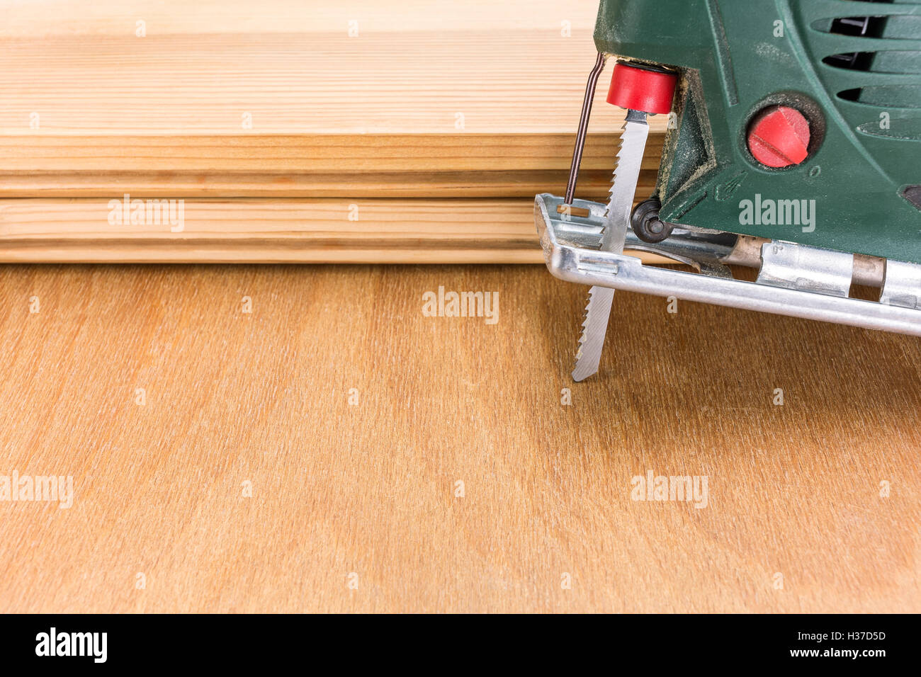 Green electric fret-saw tool on wooden background with planks Stock ...