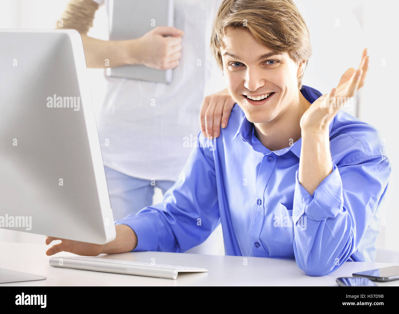 Working behind a desk, a handsome young employee Stock Photo - Alamy