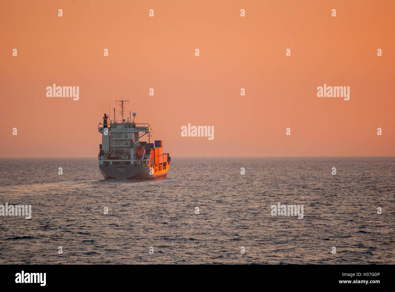 Small container ship sailing across the Agean Sea at Sunset, sailing ...
