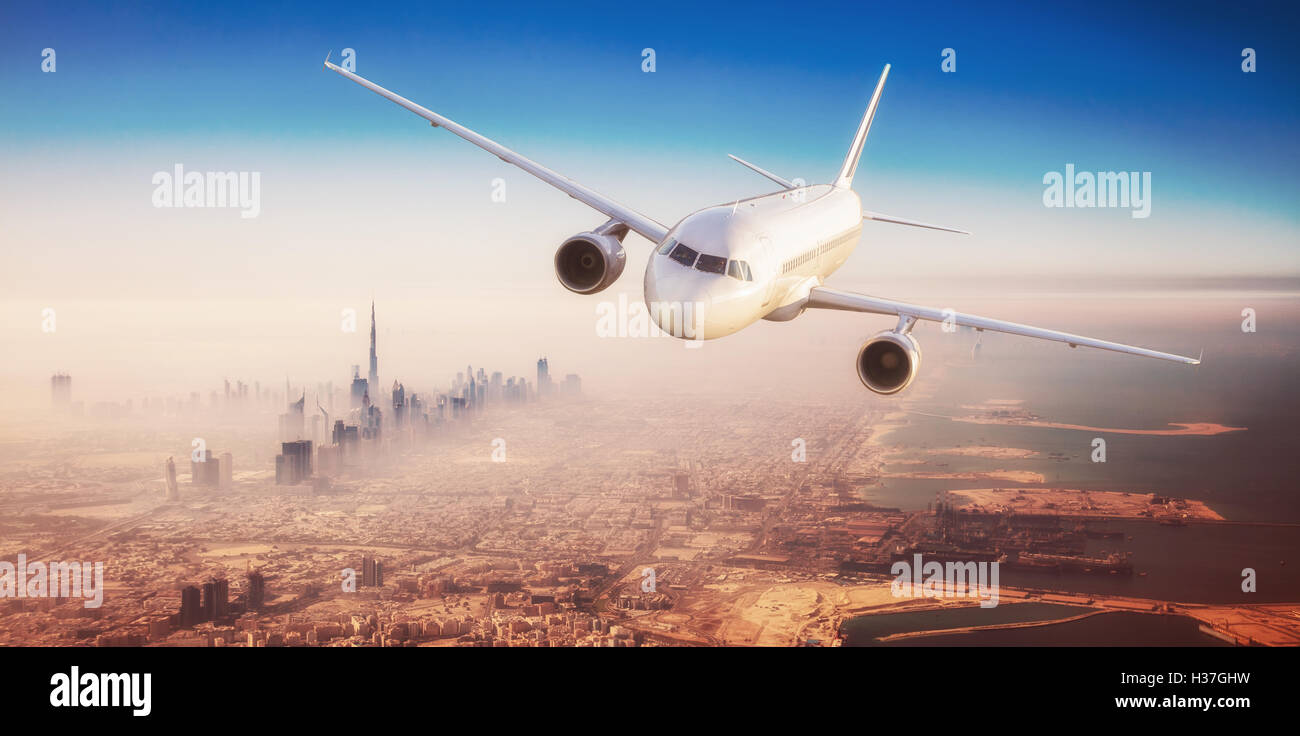 Commercial airplane flying over modern city with skyscrapers Stock ...