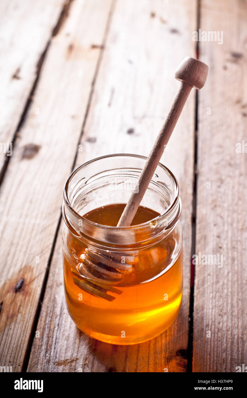 full honey pot and honey stick Stock Photo - Alamy