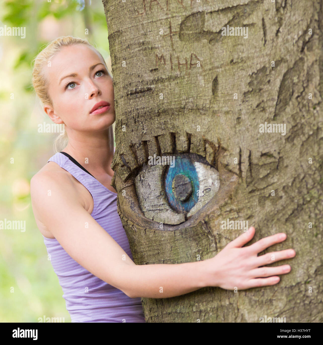 Young woman hugging a tree Stock Photo - Alamy