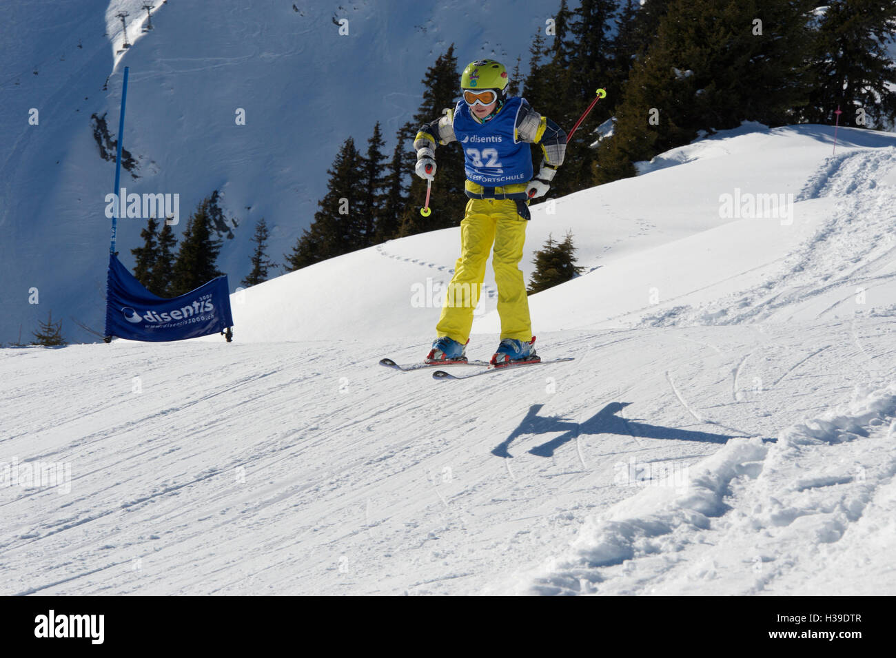 A boy skiing over a piste during a kids race Stock Photo - Alamy