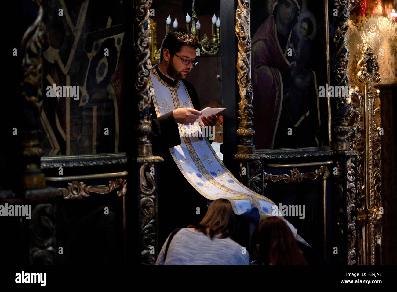 A Romanian Orthodox priest gives blessings to believers inside St ...