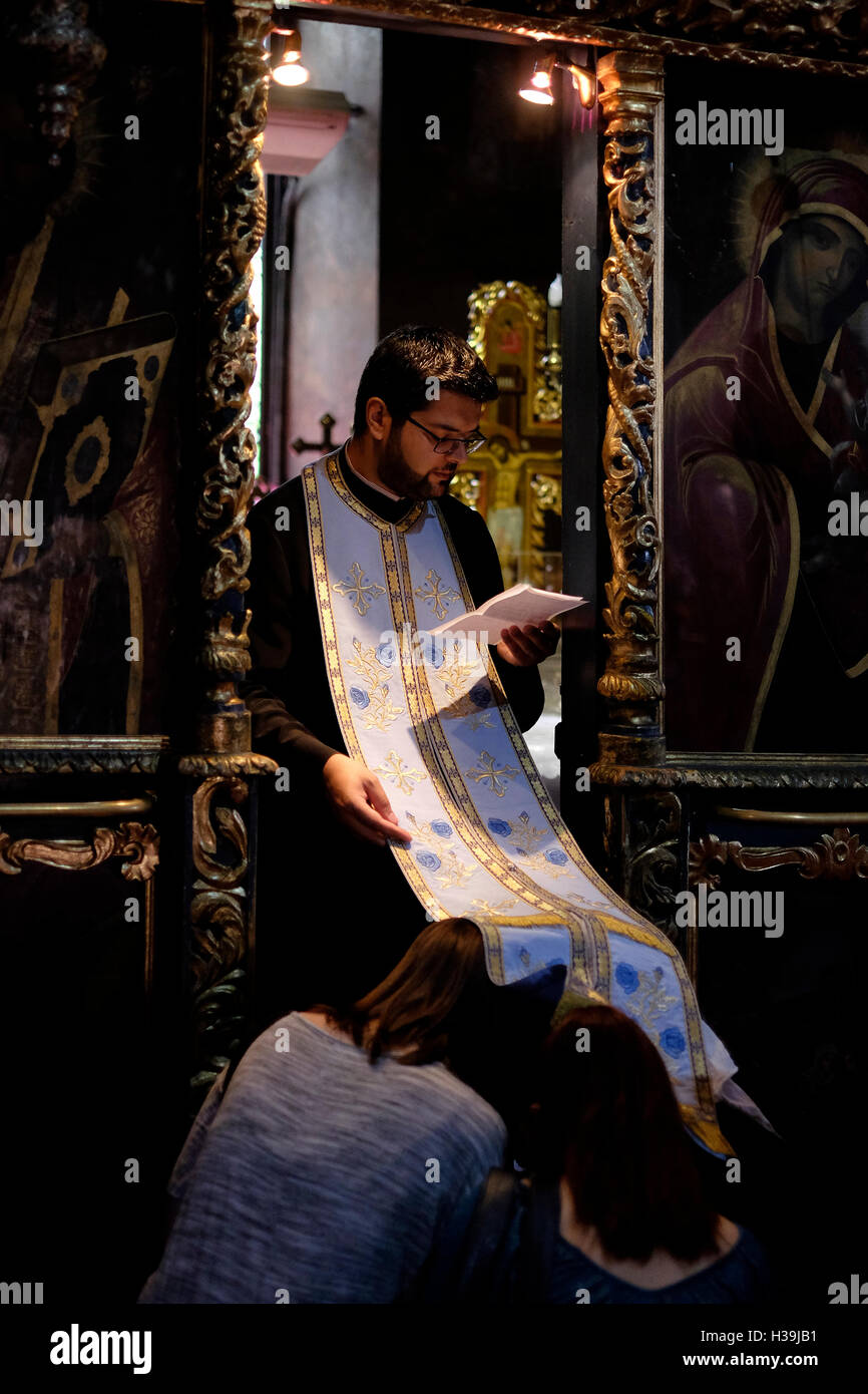 A Romanian Orthodox priest gives blessings to believers inside St ...