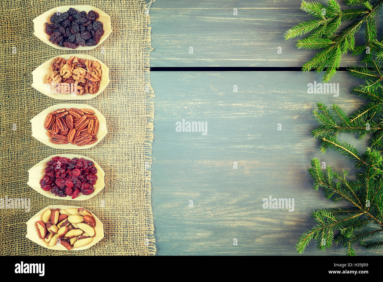 Retro toned Christmas snacks background, spruce branches, dried fruits ...