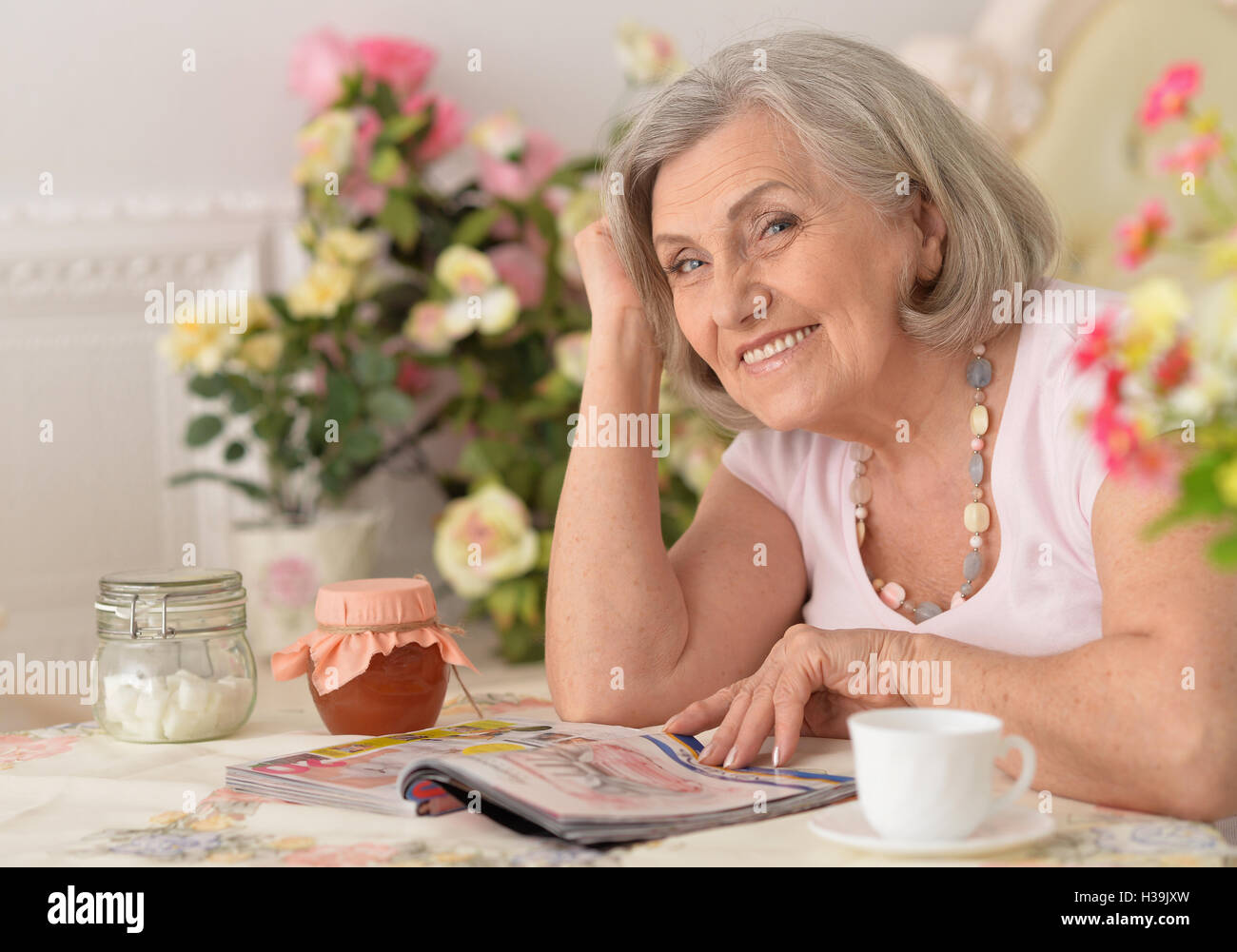 Beautiful older woman reading magazine Stock Photo - Alamy