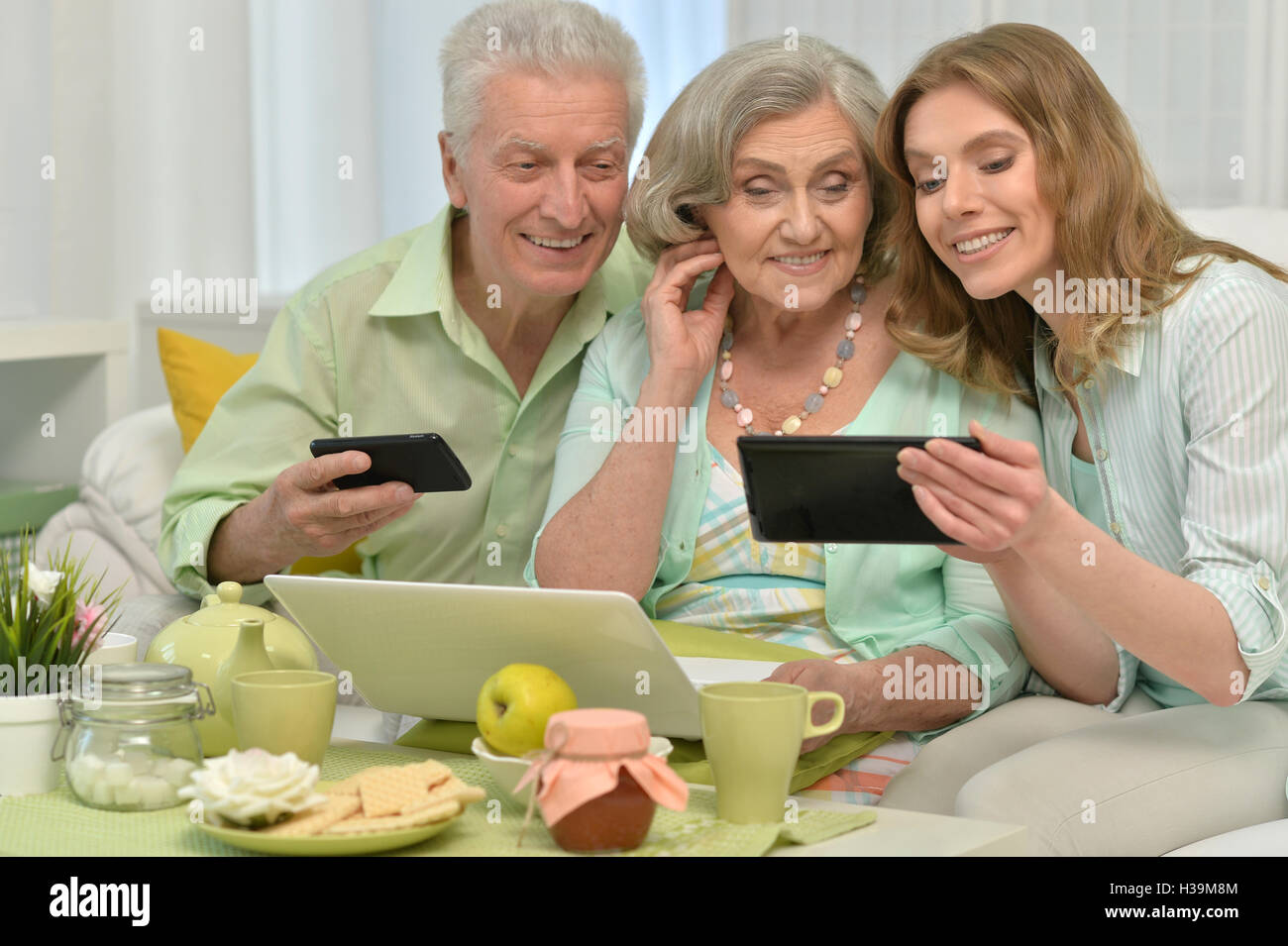daughter with senior parents drinking tea Stock Photo - Alamy