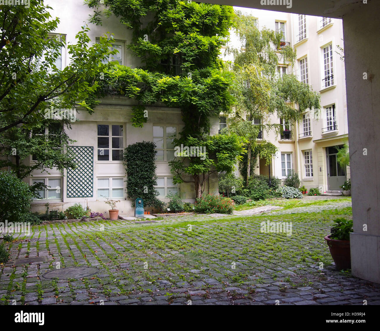 A discrete and green courtyard in Paris Stock Photo - Alamy