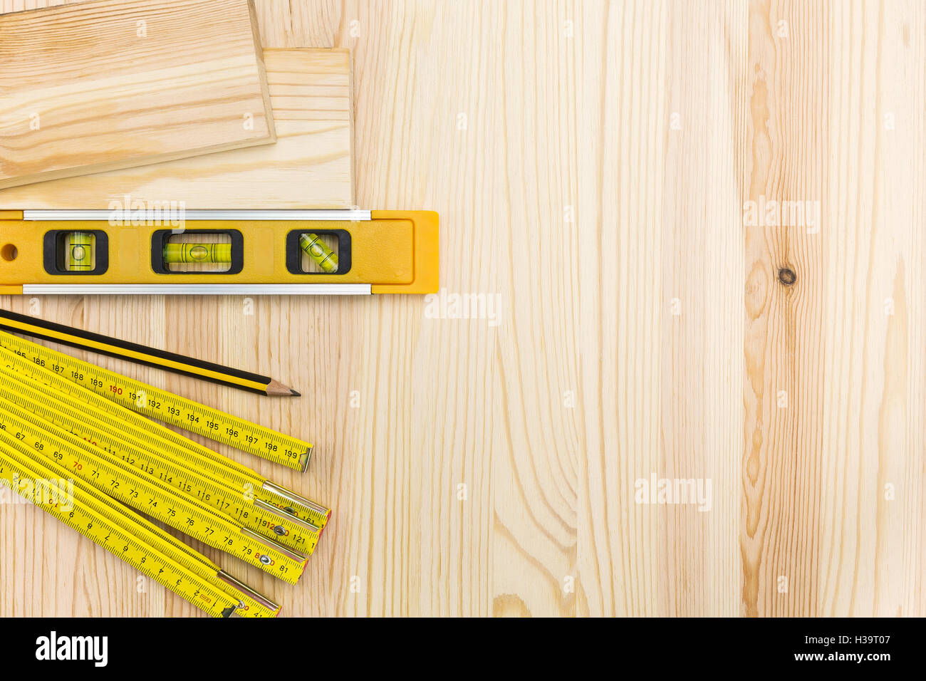 Folding rule, bubble level and pencil on wooden background Stock Photo ...
