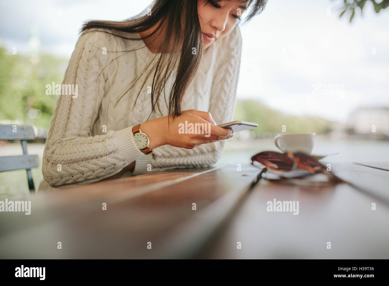 Woman typing text message on smart phone in a cafe. Image of young ...