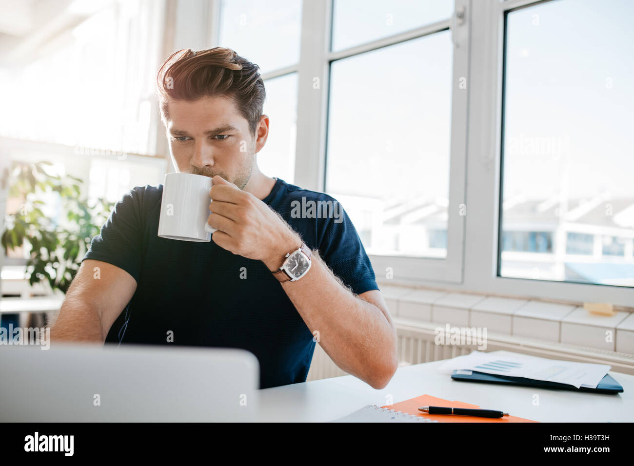 Businessman sitting on desk watching hi-res stock photography and ...