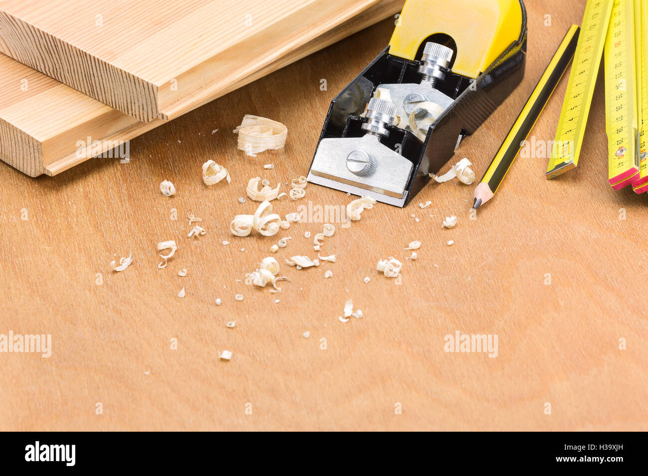 Carpenter plane with folding rule and wooden planks Stock Photo - Alamy