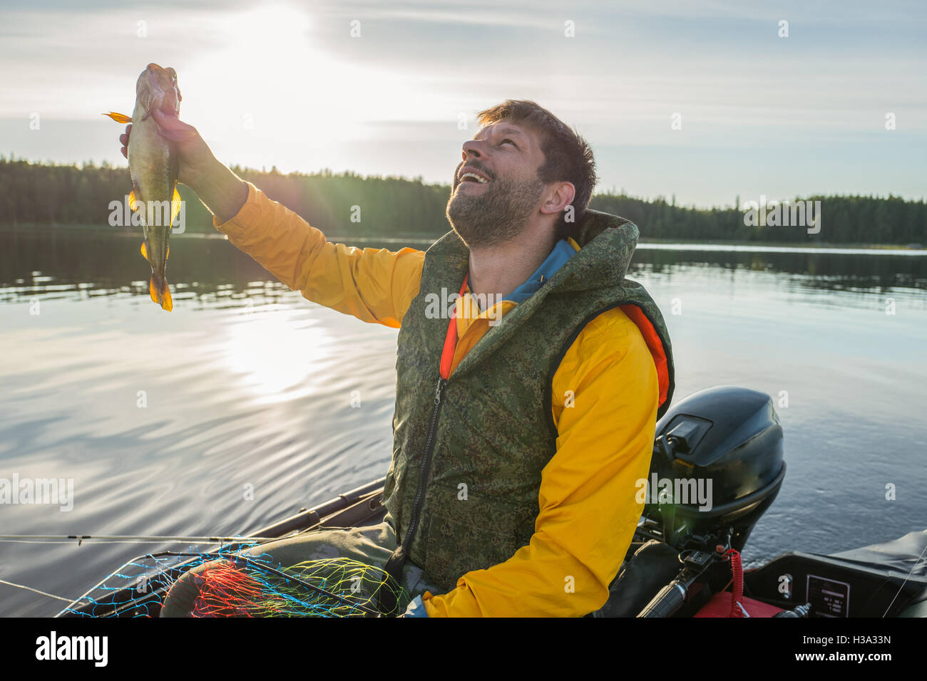 Handsome fisherman catched a haddock and looking to the sky Stock Photo ...