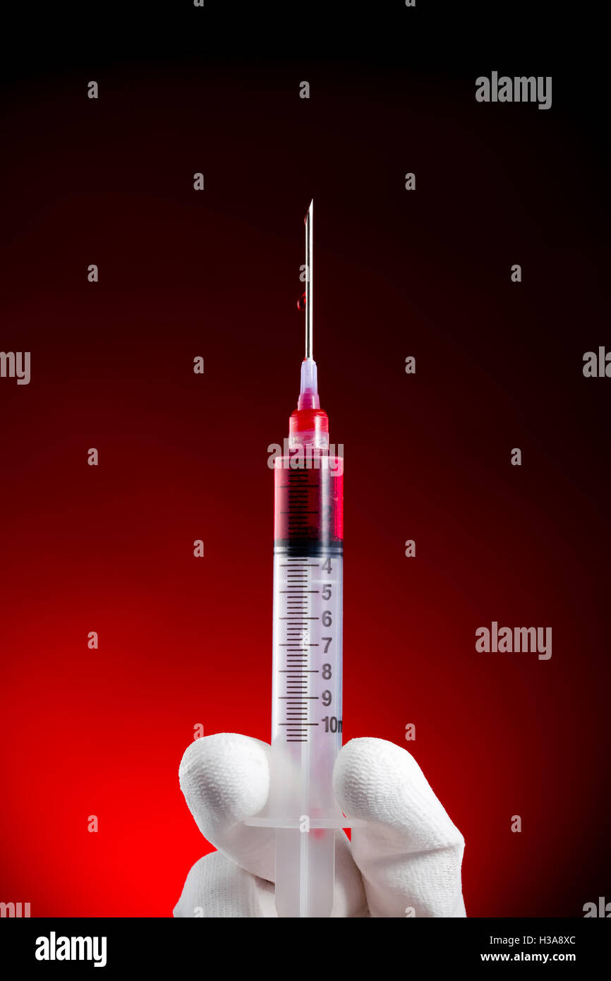 Syringe vertical pushing blood isolated on red background Stock Photo ...