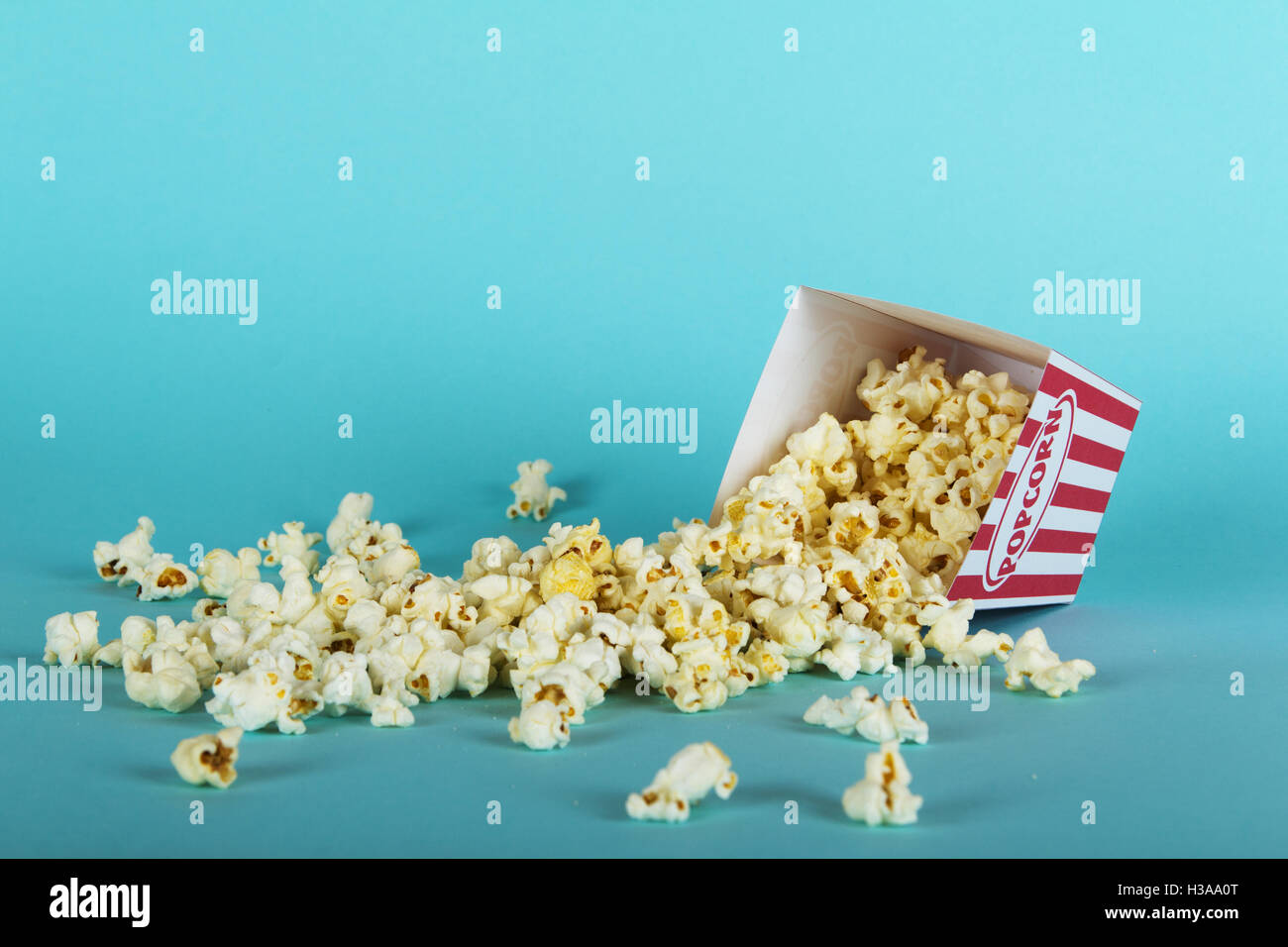 Bucket of popcorn against a blue background Stock Photo - Alamy