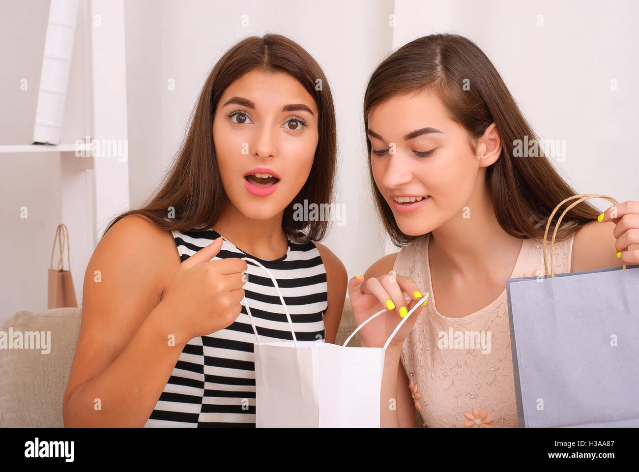 Happy women together looking purchases from shopping bags Stock Photo ...