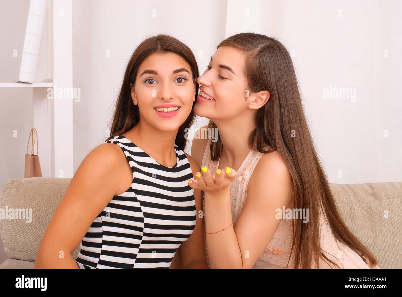 two girls gossip on gray background Stock Photo - Alamy