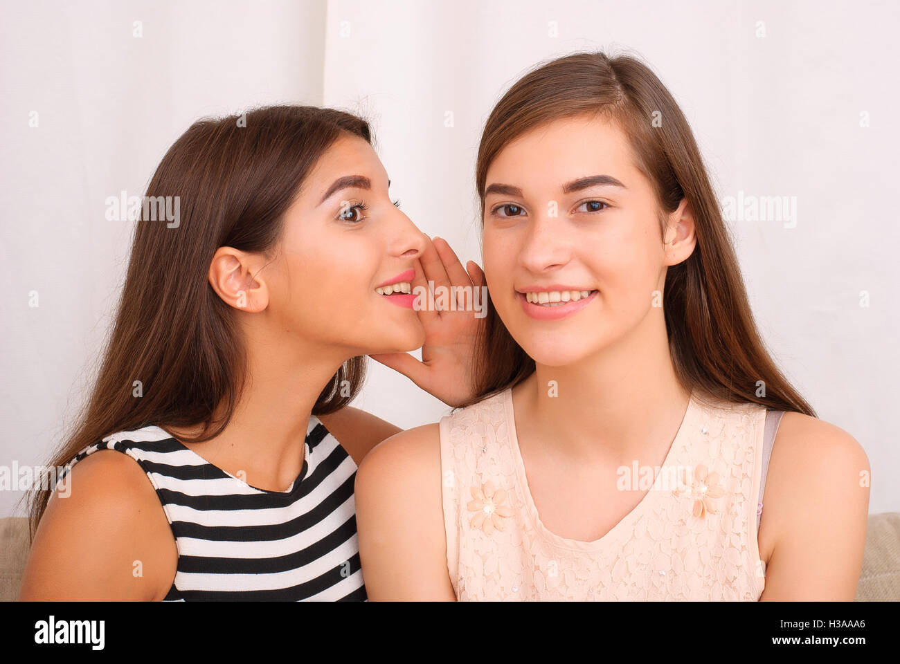 two girls gossip on gray background Stock Photo - Alamy