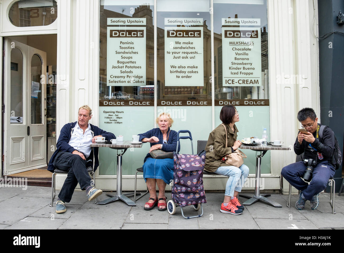 People are pictured sitting outside of a high street coffee cafe ...