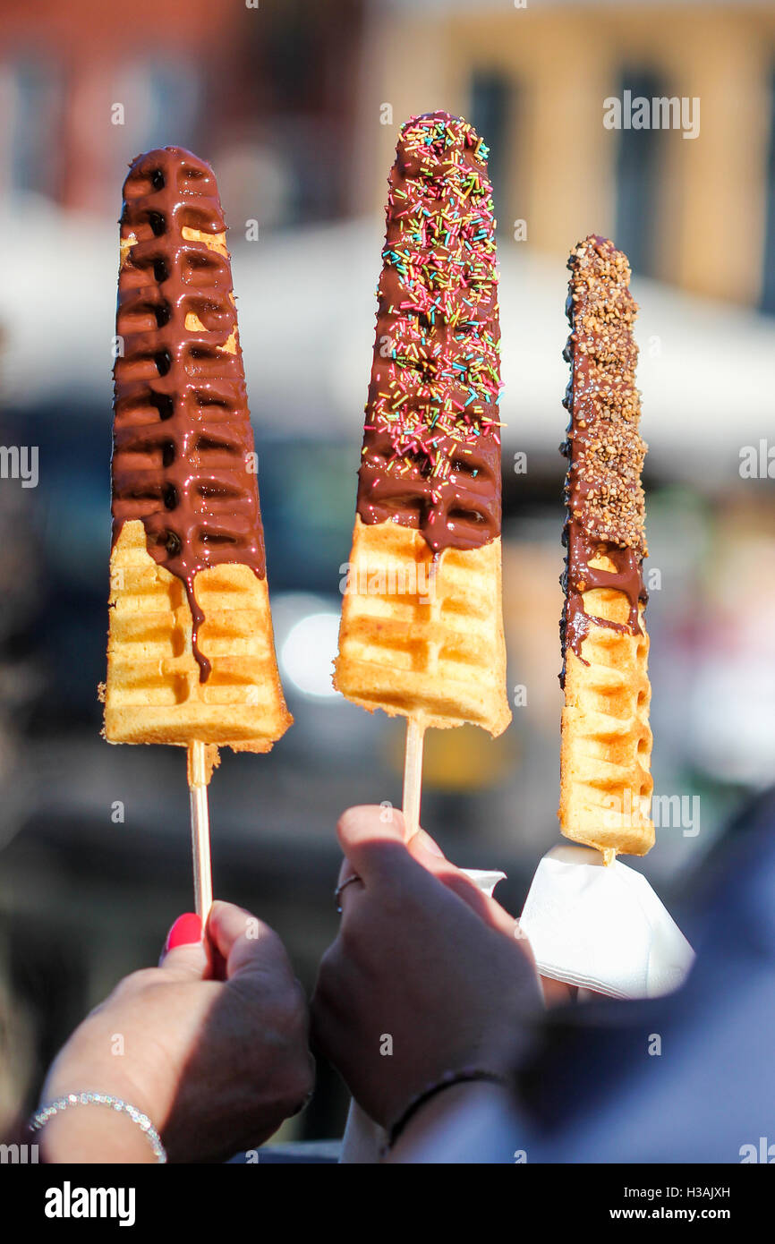 Delicious and colorful waffles in hands before eating Stock Photo - Alamy