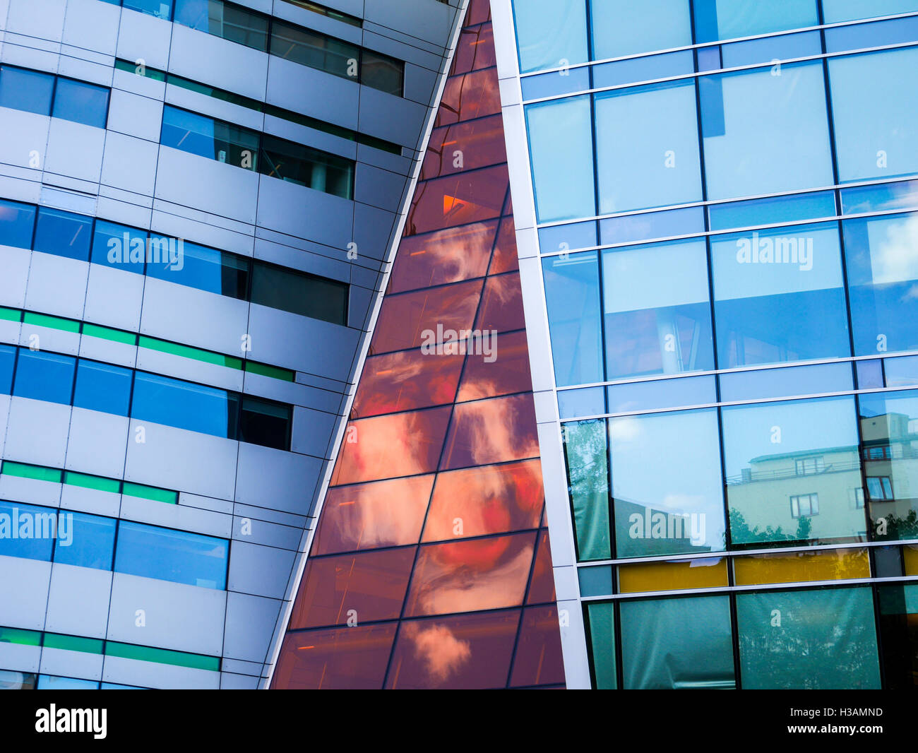 Colorful windows with a reflection of clouds on a modern building Stock ...