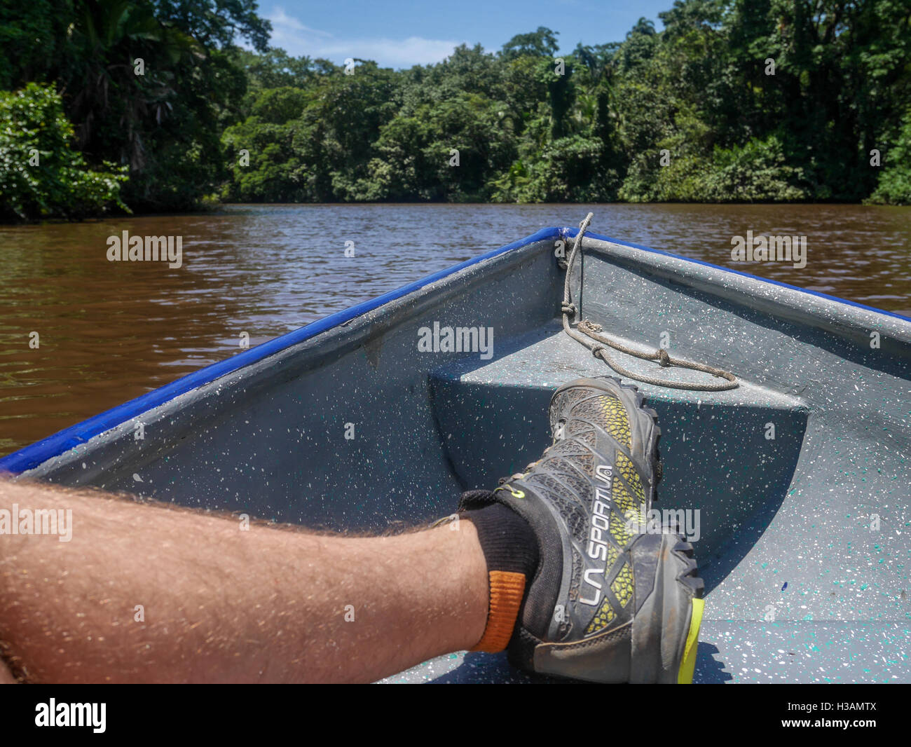 Leg of a man sitting and enjoying tour on a river in a wild jungle in ...
