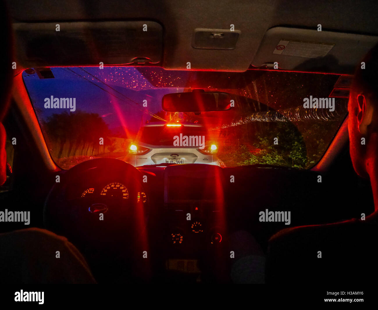 Looking through the front car window to other car in front with red ...