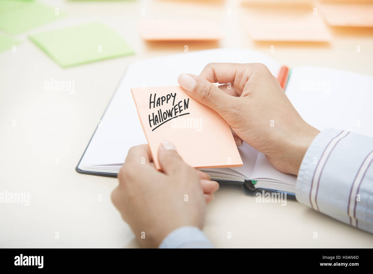 Hands holding sticky note with Happy Halloween text Stock Photo - Alamy