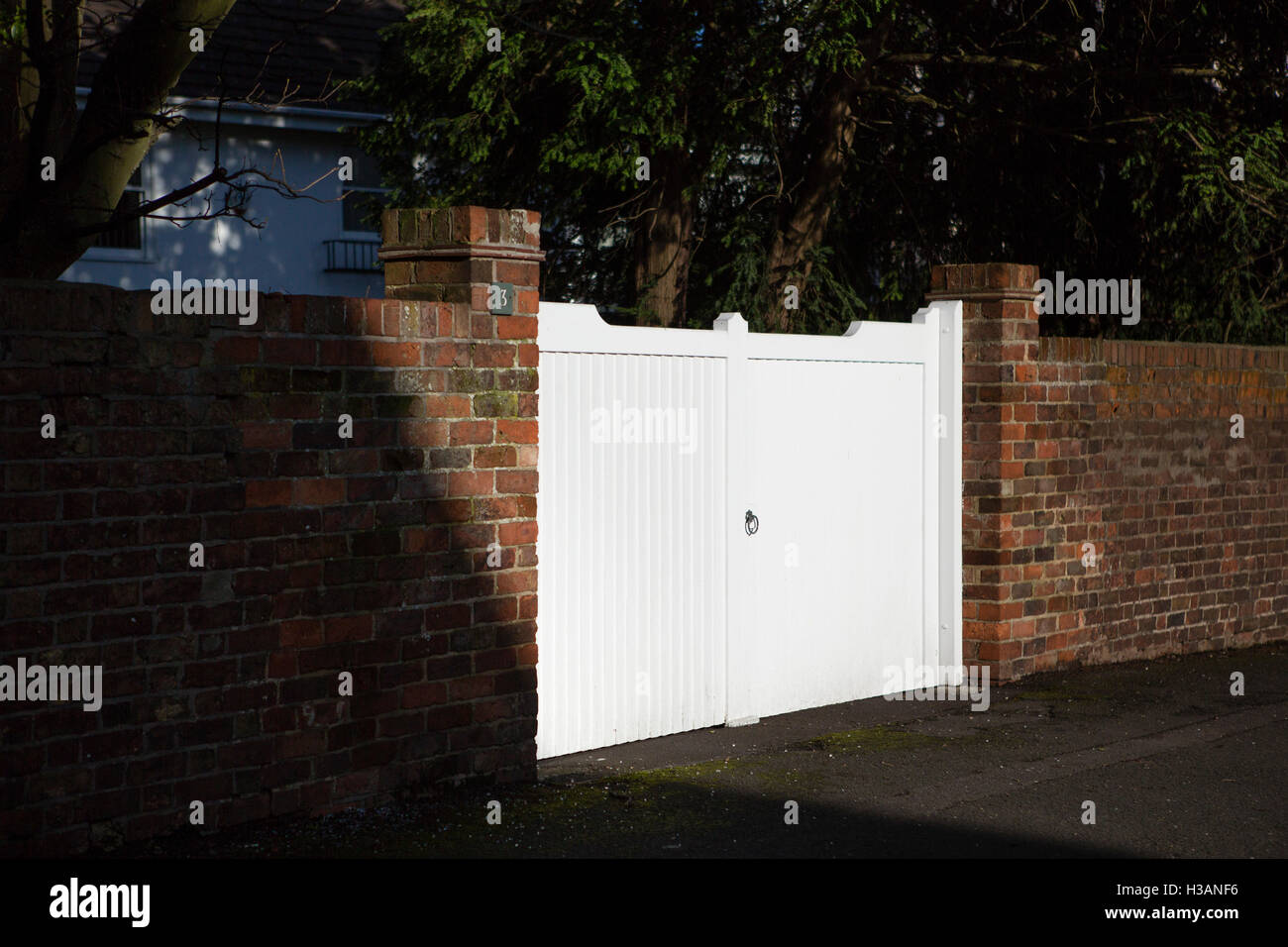Closed white painted gate to a large house Stock Photo - Alamy