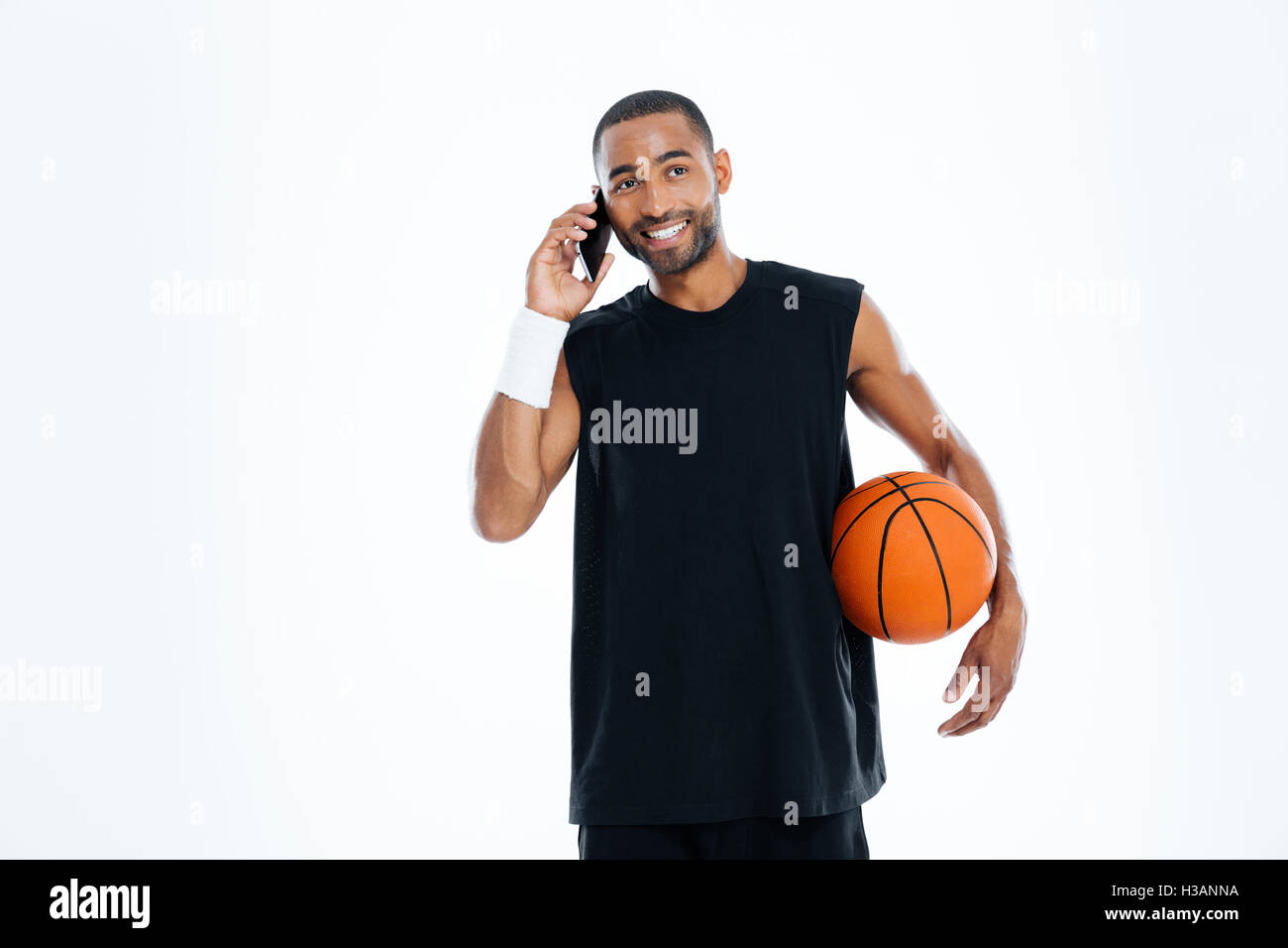 Happy african young basketball player talking on mobile phone isolated ...