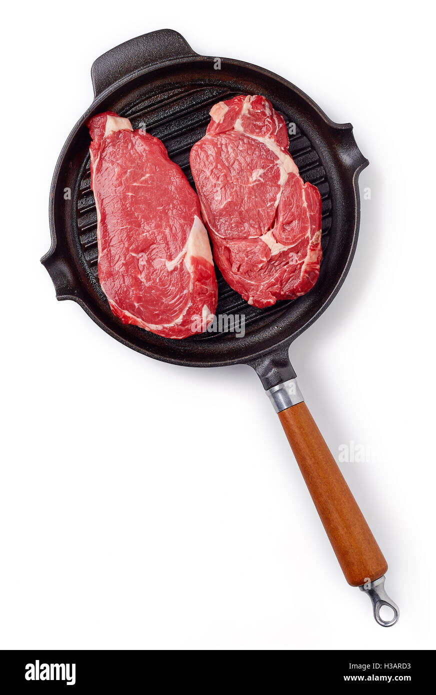 Raw beef steak on grill pan ready to cook, isolated on white background ...