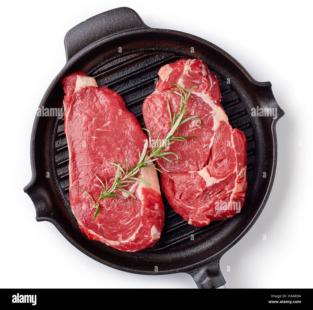 Raw beef steak on grill pan ready to cook, isolated on white background ...