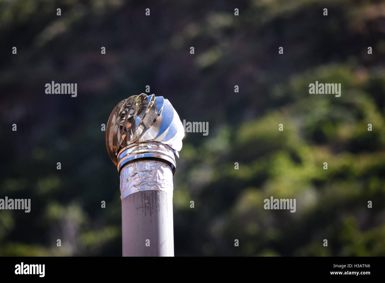 Shiny air duct on the top of chimney Stock Photo - Alamy