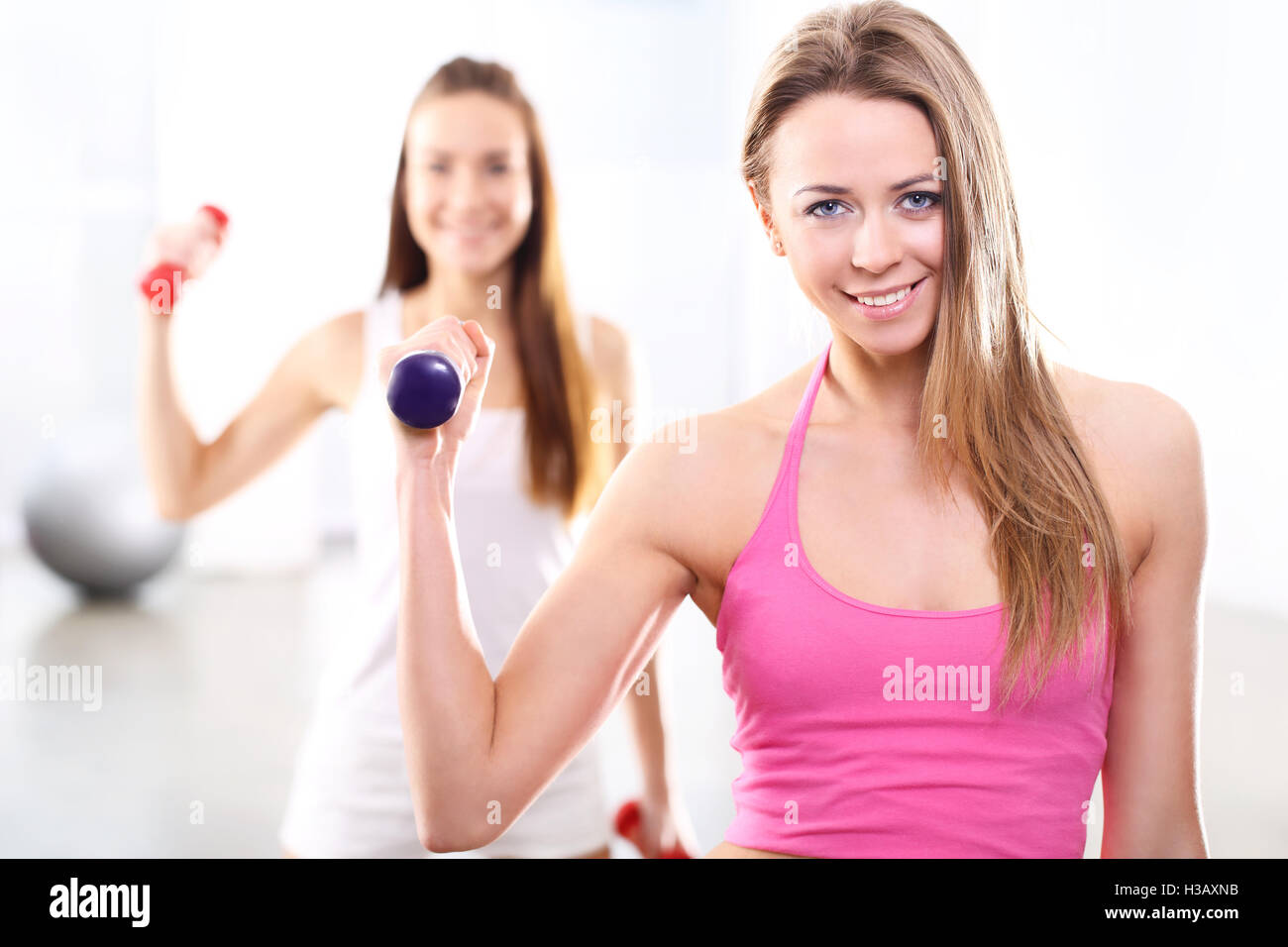 Training with weights, two young women in the gym Stock Photo - Alamy
