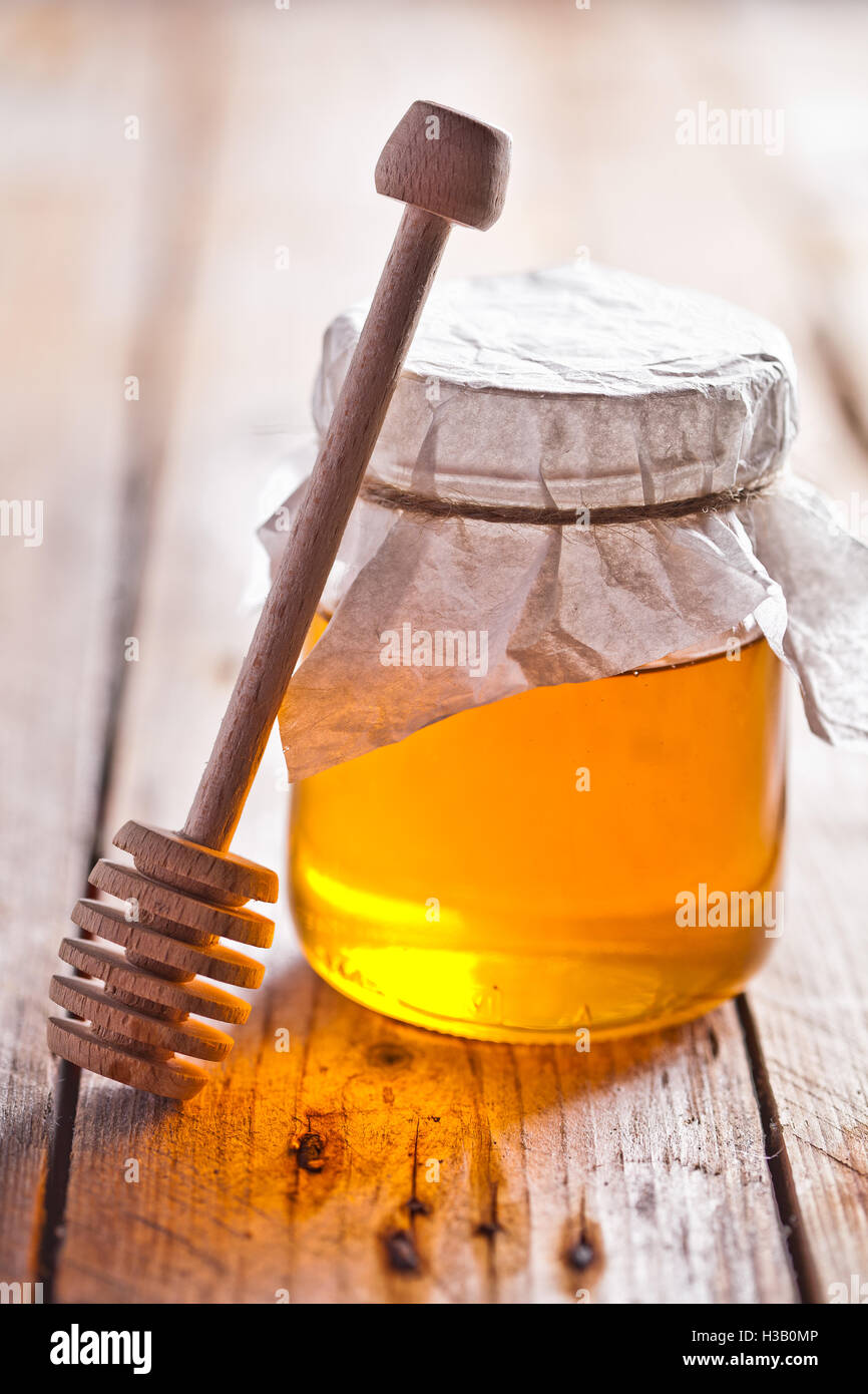 full honey pot and honey stick Stock Photo - Alamy