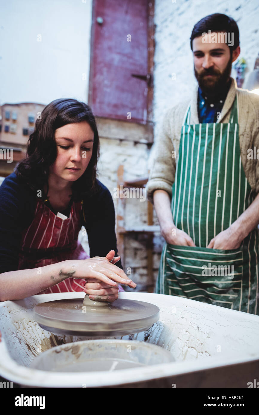 Focused young woman with colleague making pot Stock Photo - Alamy