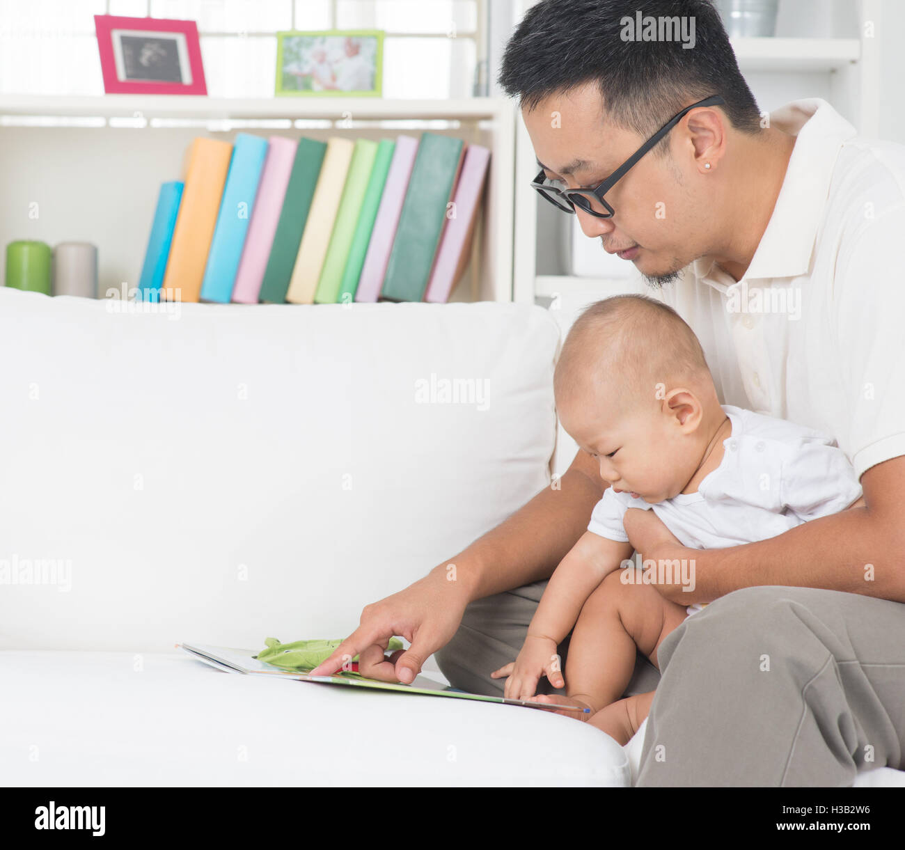 Father and baby reading story book Stock Photo - Alamy