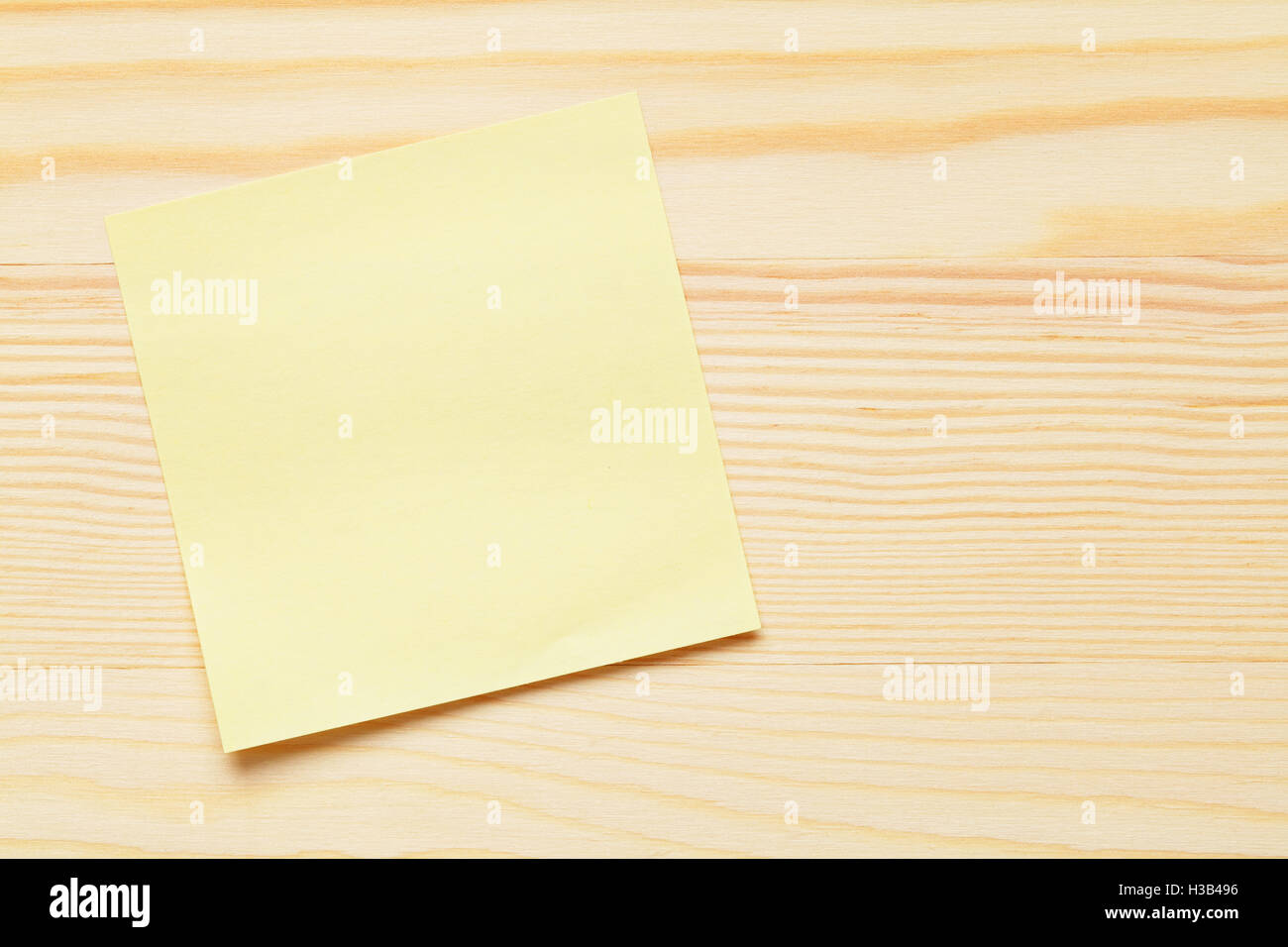 Yellow notepad over wooden background Stock Photo - Alamy