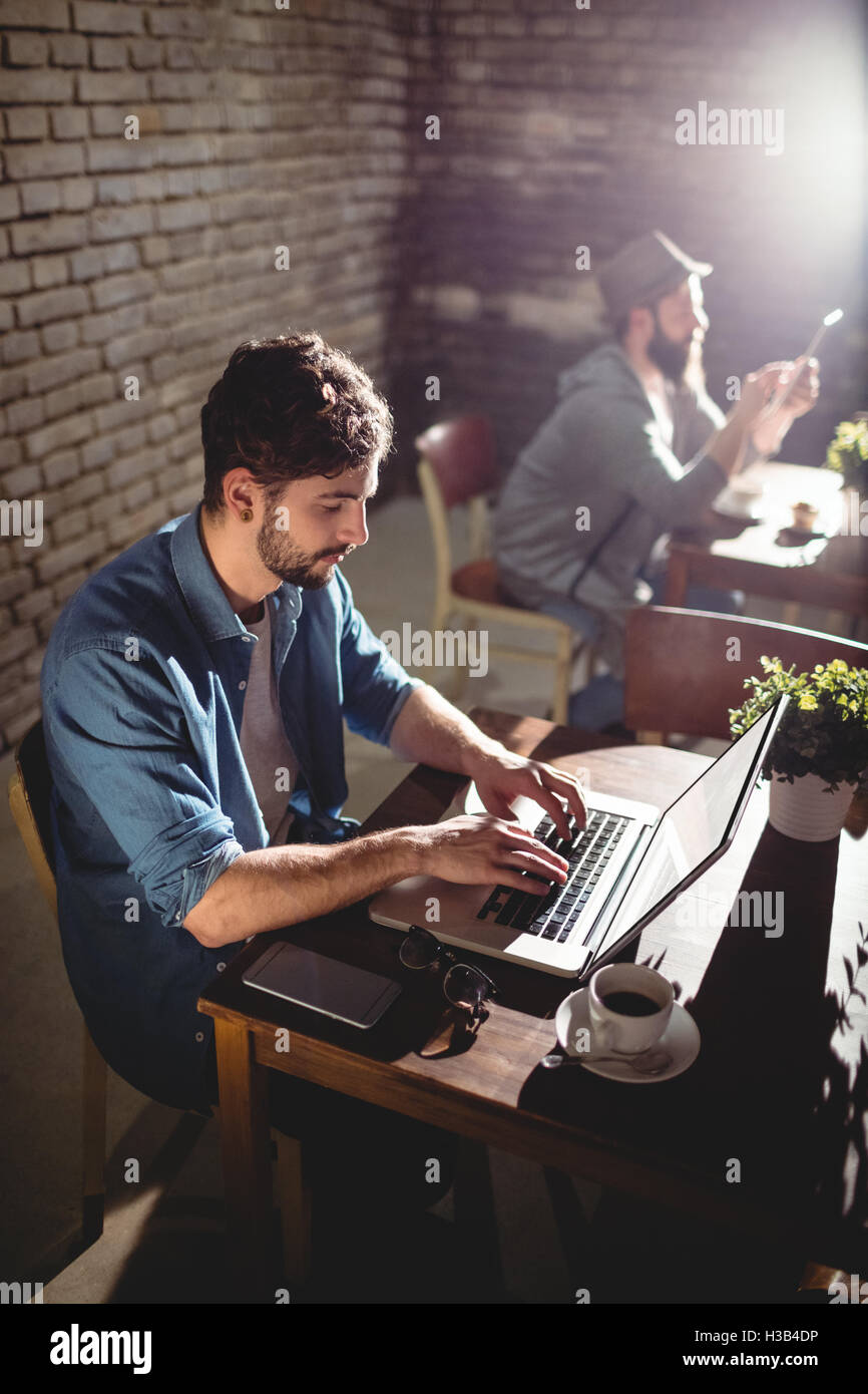 Handsome man working on laptop at cafe Stock Photo - Alamy