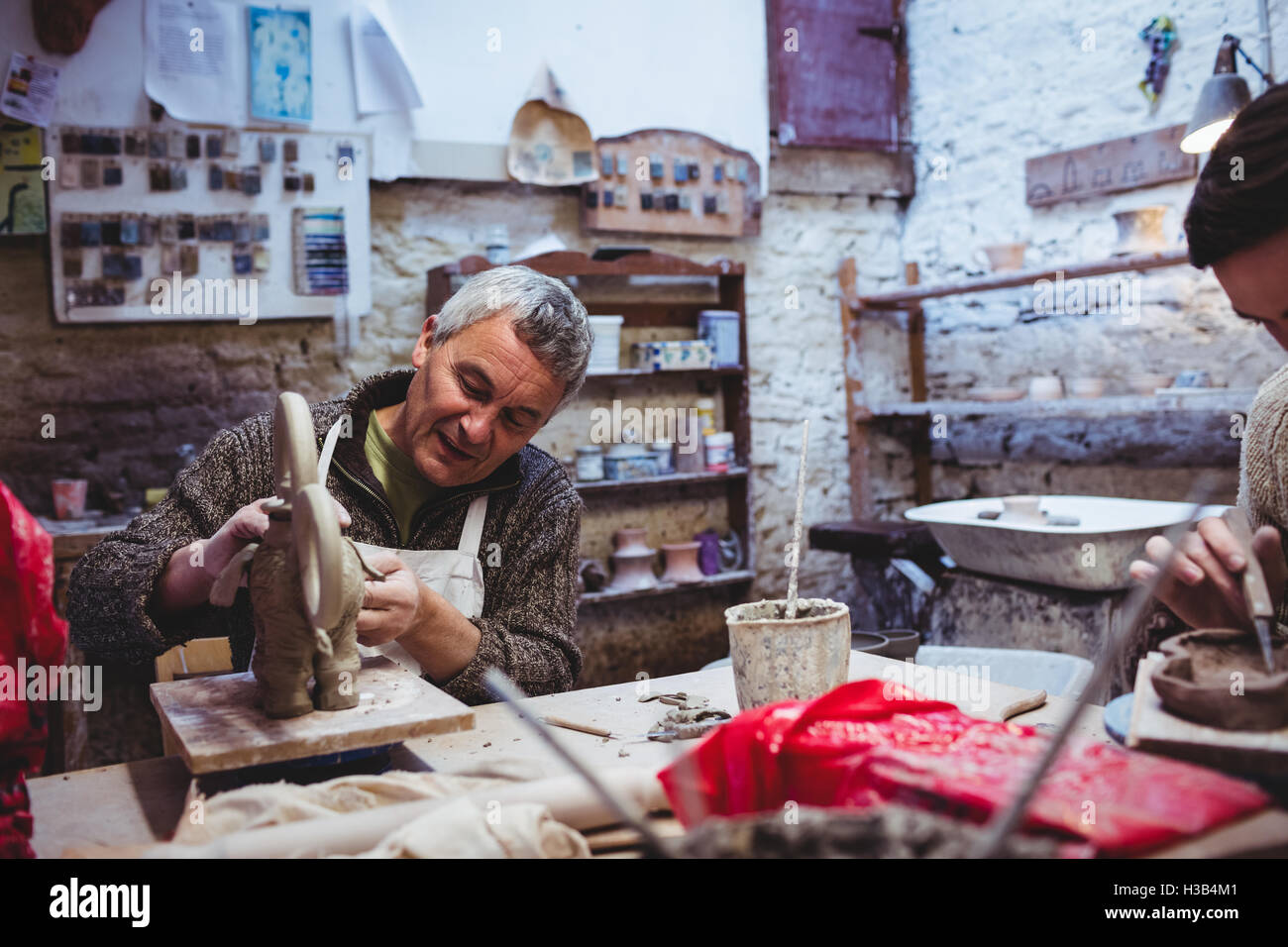 Concentrated male craftsperson working at table Stock Photo - Alamy