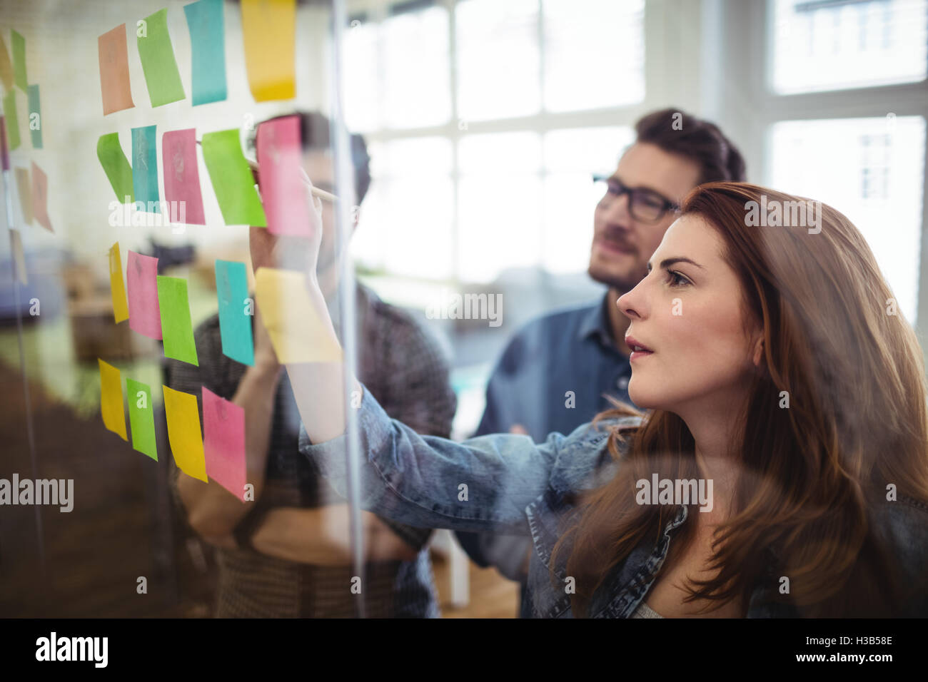 Woman writing on sticky paper hi-res stock photography and images - Alamy