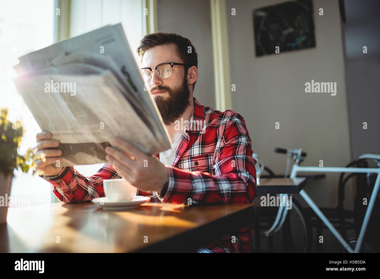 Customer reading newspaper with coffee at cafe Stock Photo - Alamy