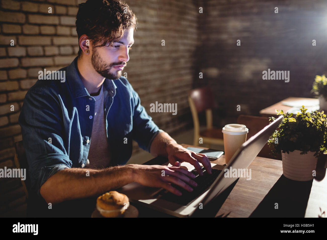 Young man concentrating on laptop while sitting at cafe Stock Photo - Alamy