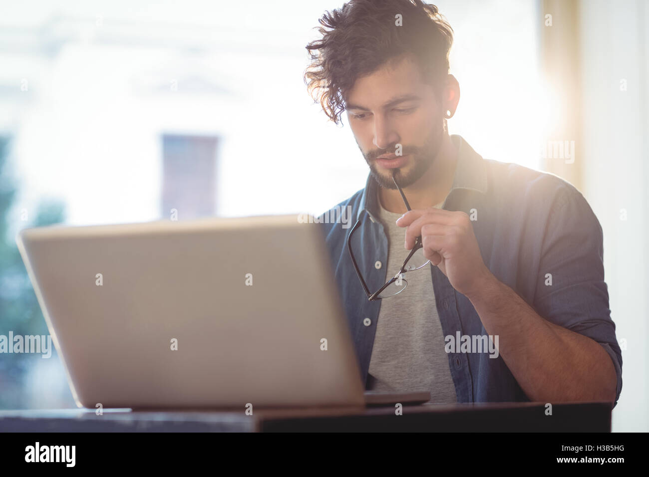 Handsome male customer using laptop at cafeteria Stock Photo - Alamy