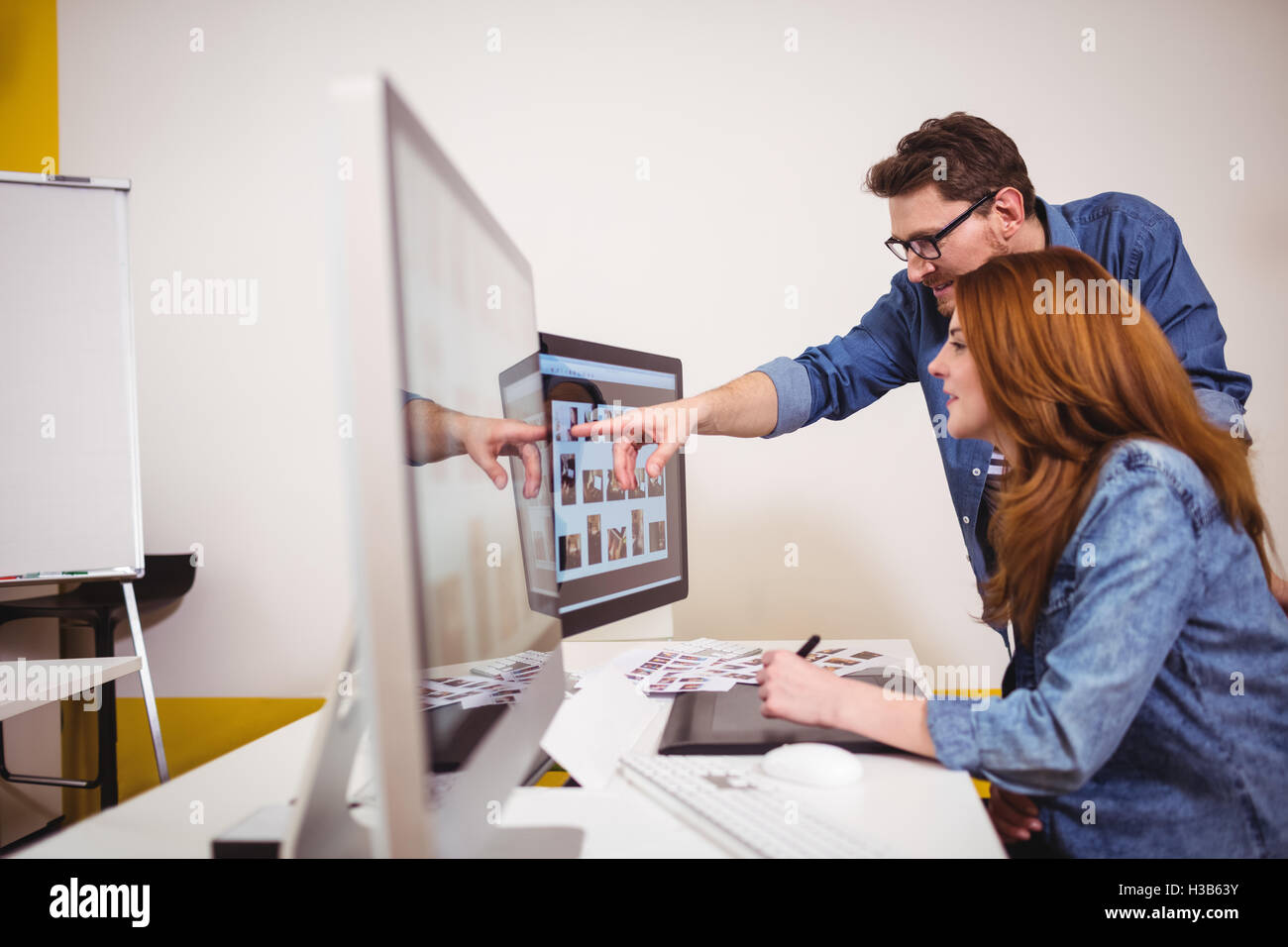 Businessman showing computer screen to female coworkers Stock Photo - Alamy
