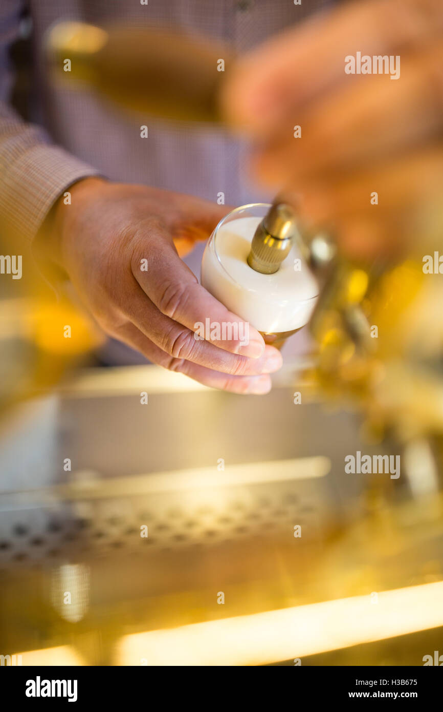 Brewer filling beer in beer glass from beer pump Stock Photo - Alamy