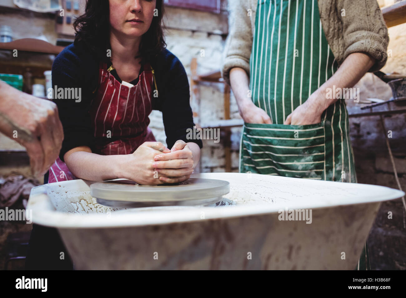 Woman with male colleagues making pot Stock Photo - Alamy