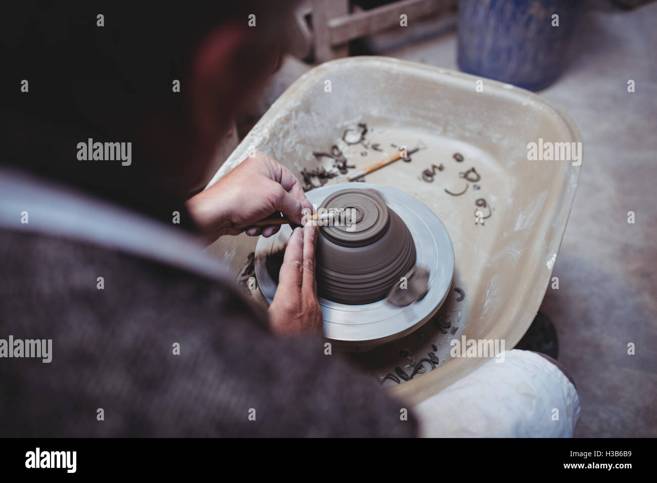 Rear view of craftsman making ceramic container Stock Photo - Alamy